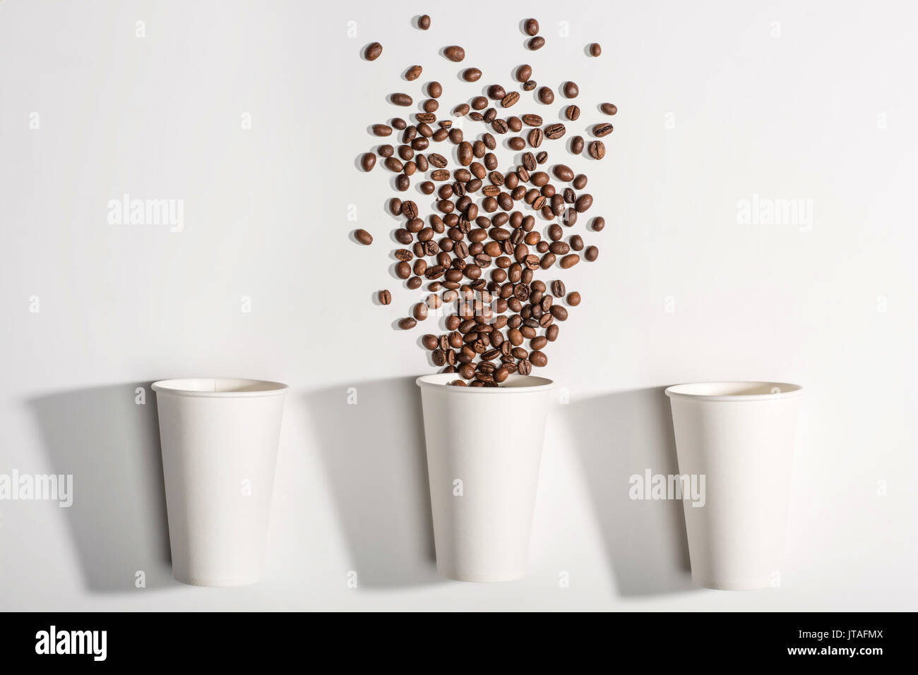 top view of white disposable paper cups with coffee beans isolated on ...