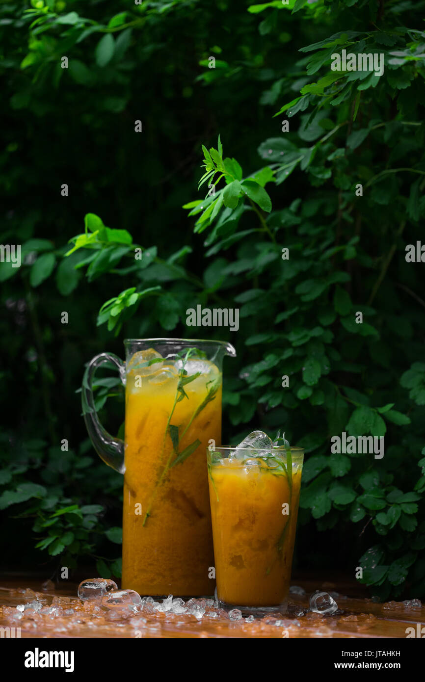 Citrus lemonade with herbs on a wooden background. Orange lemonade with ...