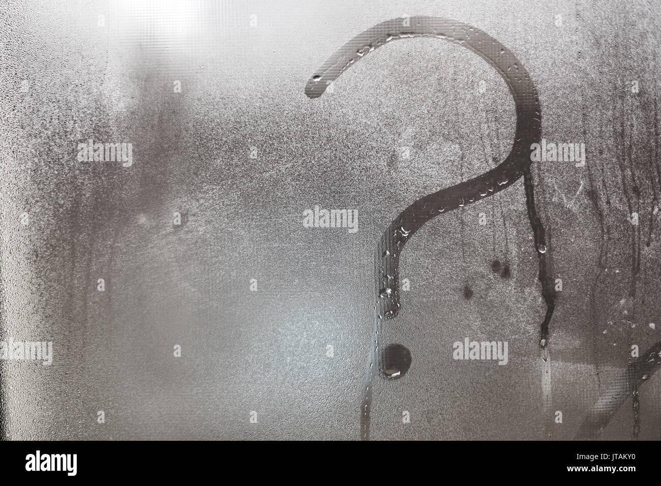 Blurry question mark on foggy condensation window glass natural surface ...