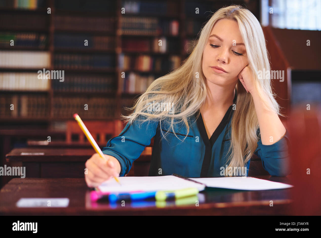 Young woman learning in library Stock Photo - Alamy