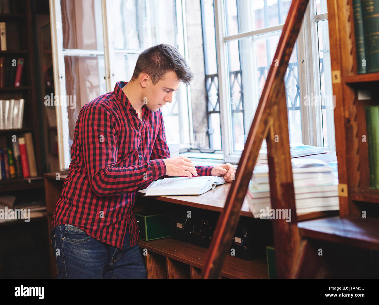 College student reading book in college library Stock Photo - Alamy