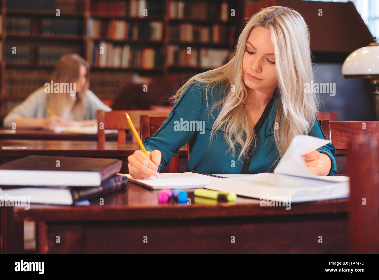 Female student at work in library Stock Photo - Alamy