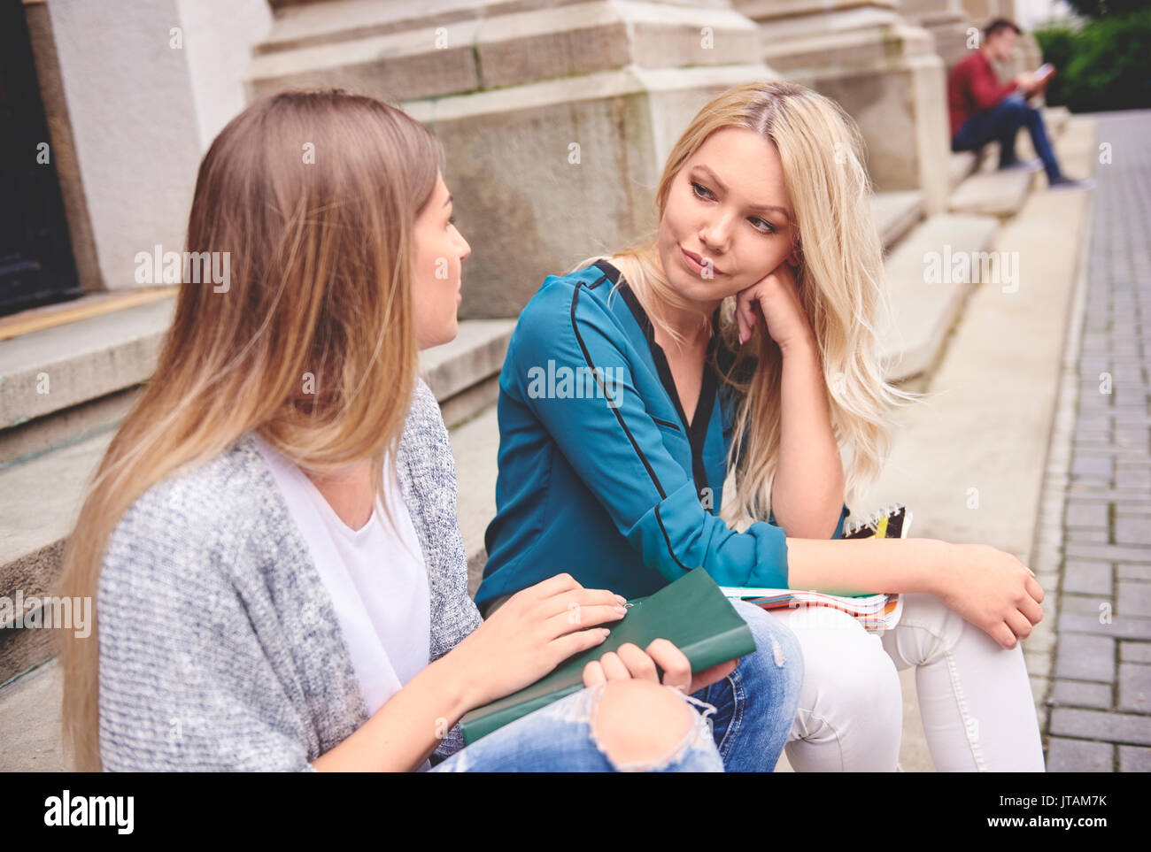 Two female students sitting and talking Stock Photo - Alamy
