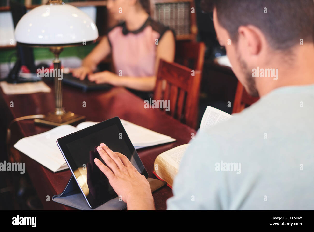 Man using tablet in library hi-res stock photography and images - Alamy