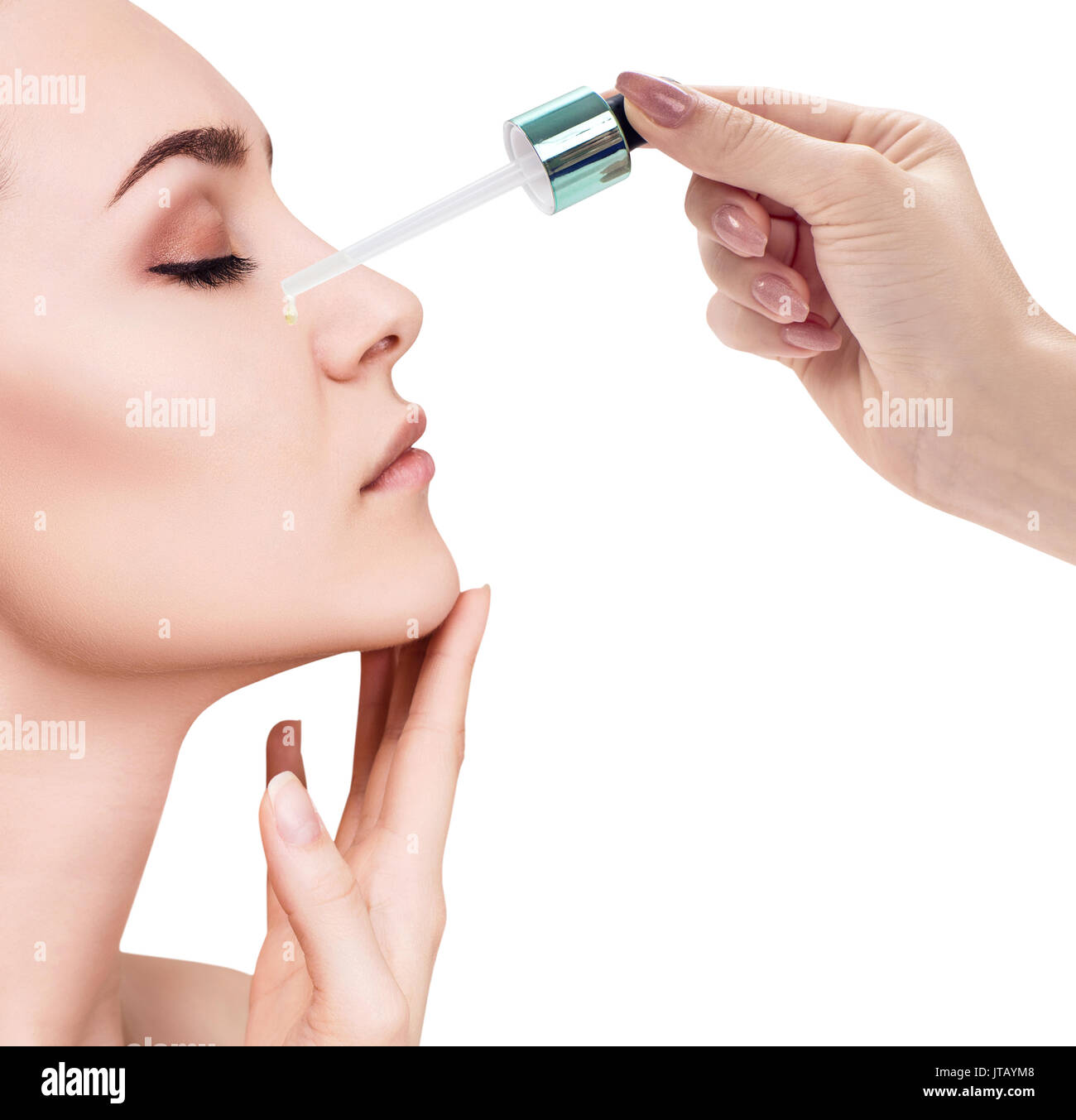Cosmetic oil applying on face of young woman. Beauty therapy concept ...