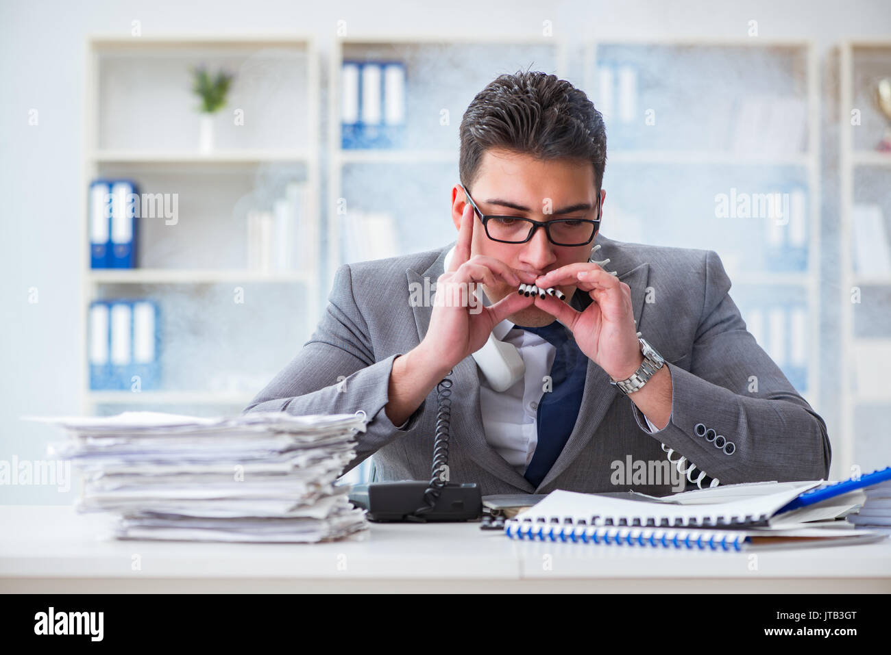 Businessman smoking in office at work Stock Photo - Alamy