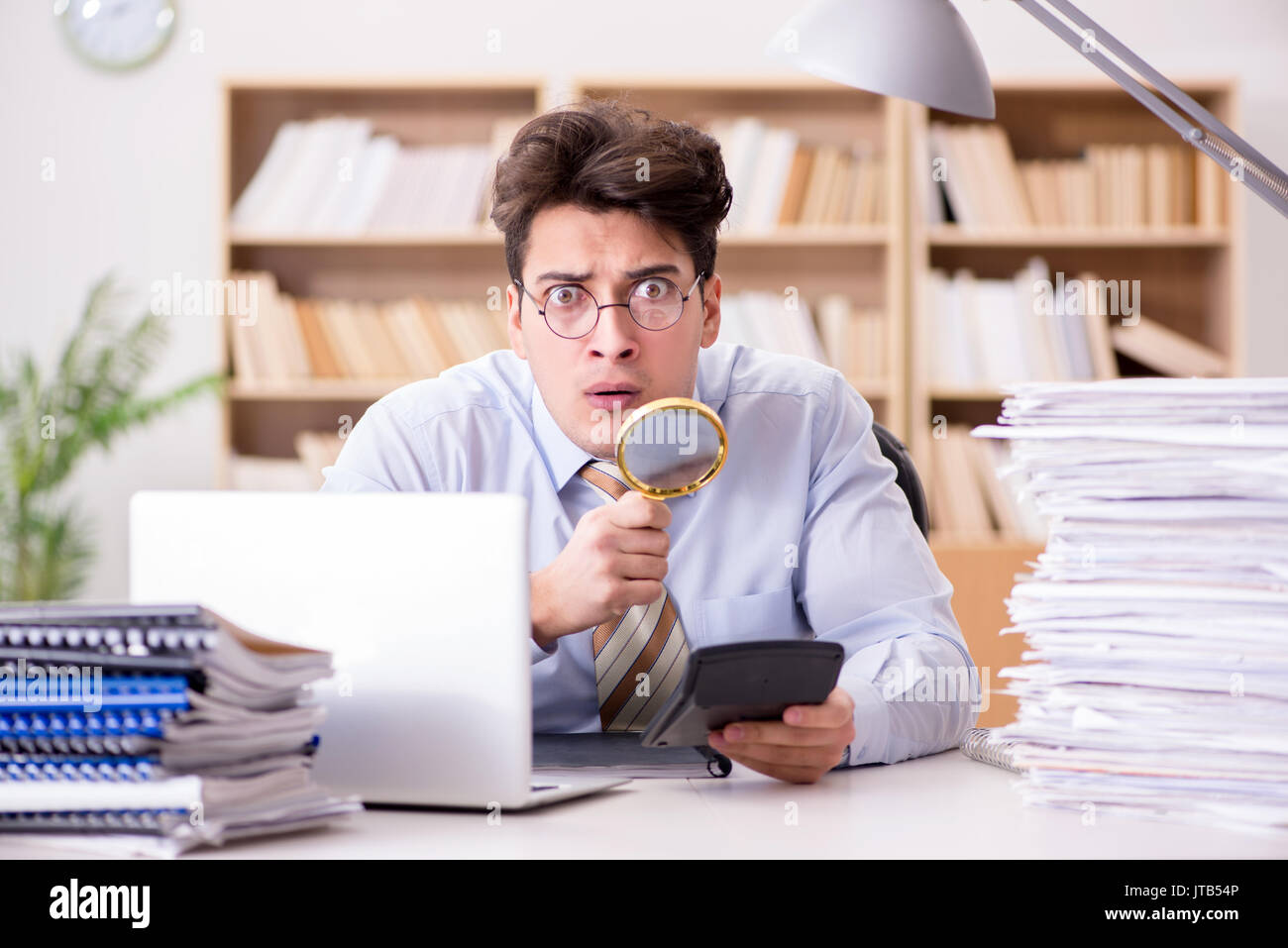 Mad auditor looking for errors in the report Stock Photo - Alamy