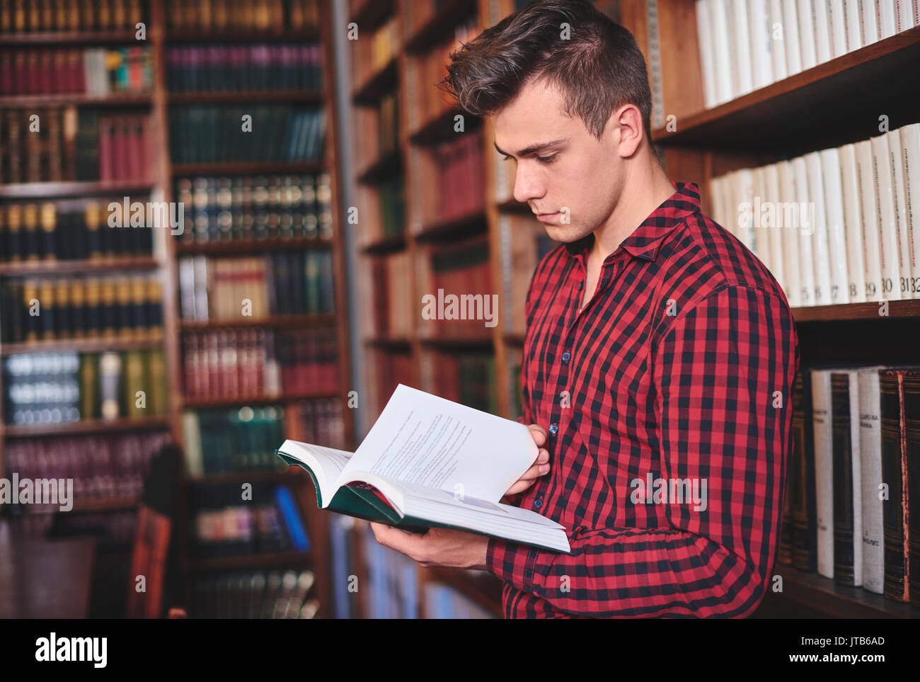 Man browsing a book in library Stock Photo - Alamy