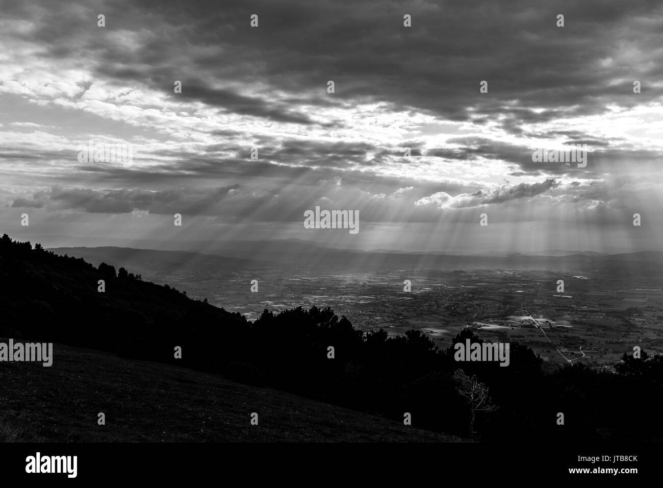 View of a valley from a mountain, with sun rays coming out through the ...