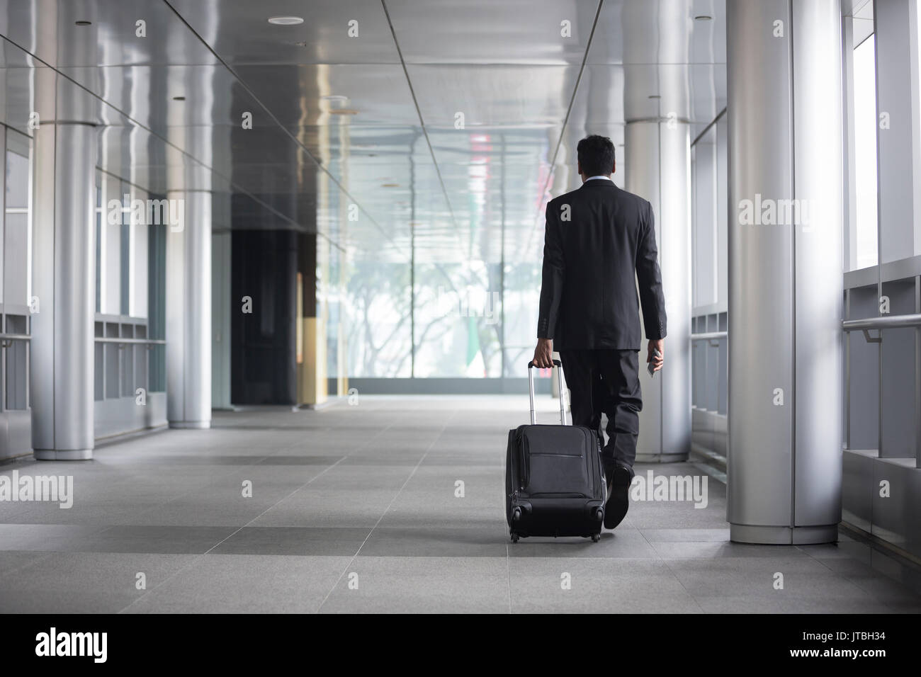 Back view of an Indian businessman walking away from camera in the city ...