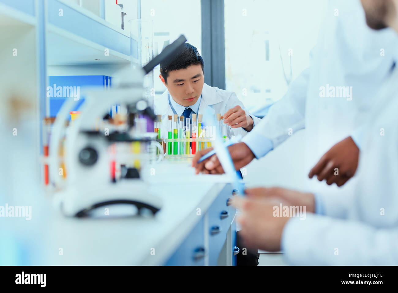 young doctors in uniform working at testing laboratory, chemical ...