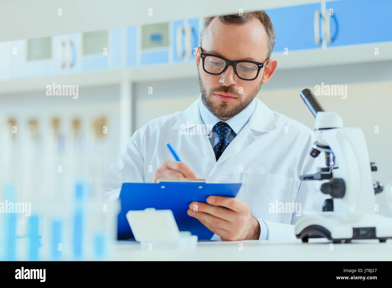 young doctor in uniform working at testing laboratory at clinic ...