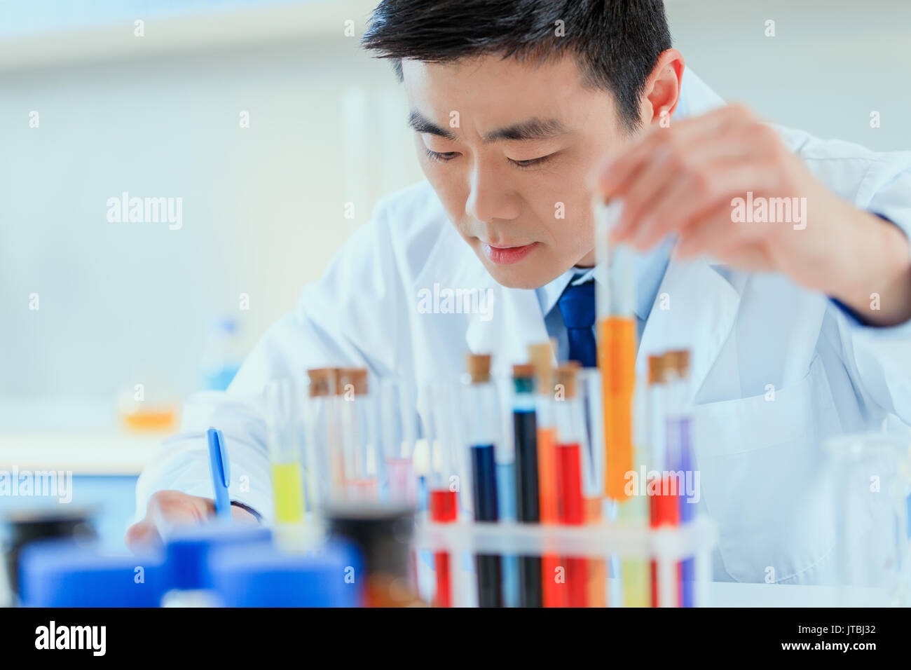young asian doctor in uniform working at testing laboratory, chemical ...