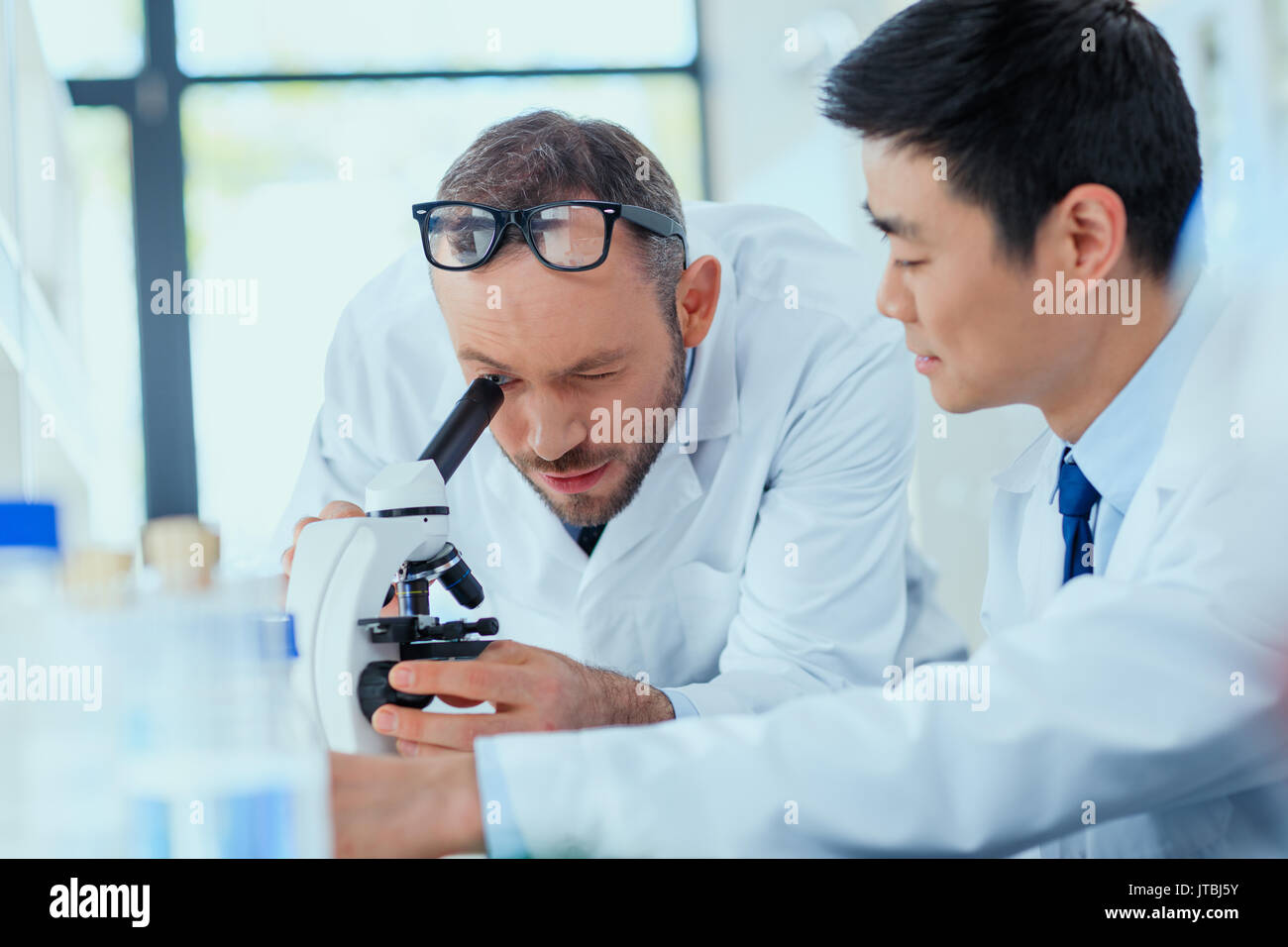 Professional scientists in white coats working together in chemical ...