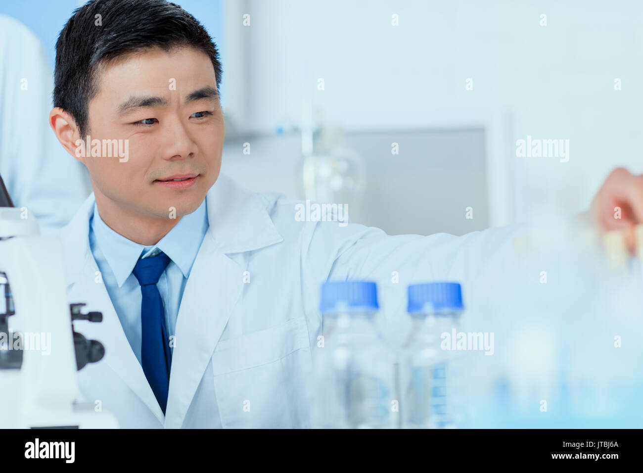 Asian scientist in white coat working in chemical laboratory Stock ...