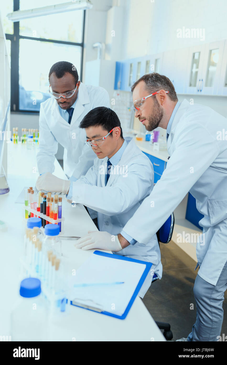 Professional scientists in white coats working together in chemical ...