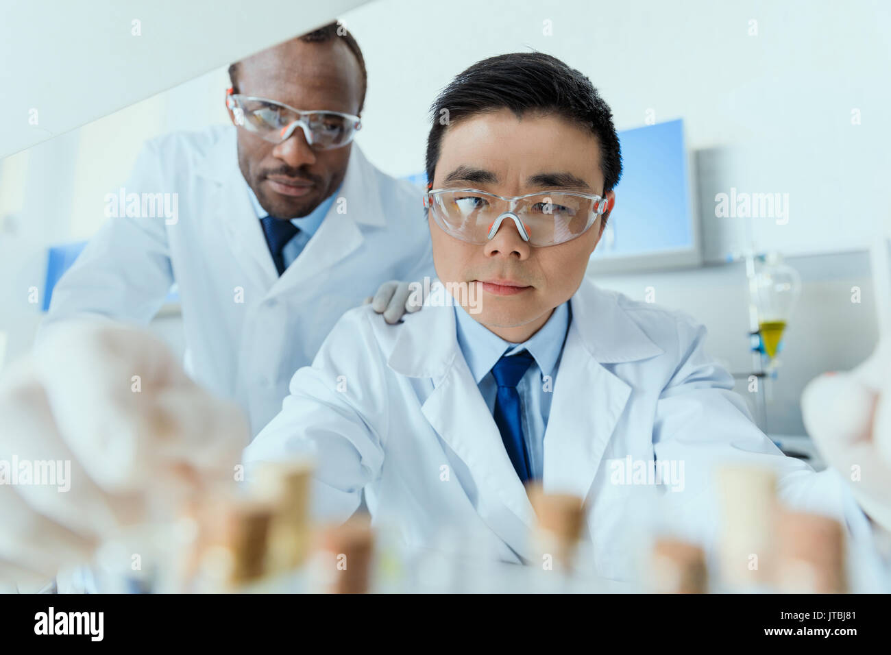 Professional scientists in white coats working together in chemical ...