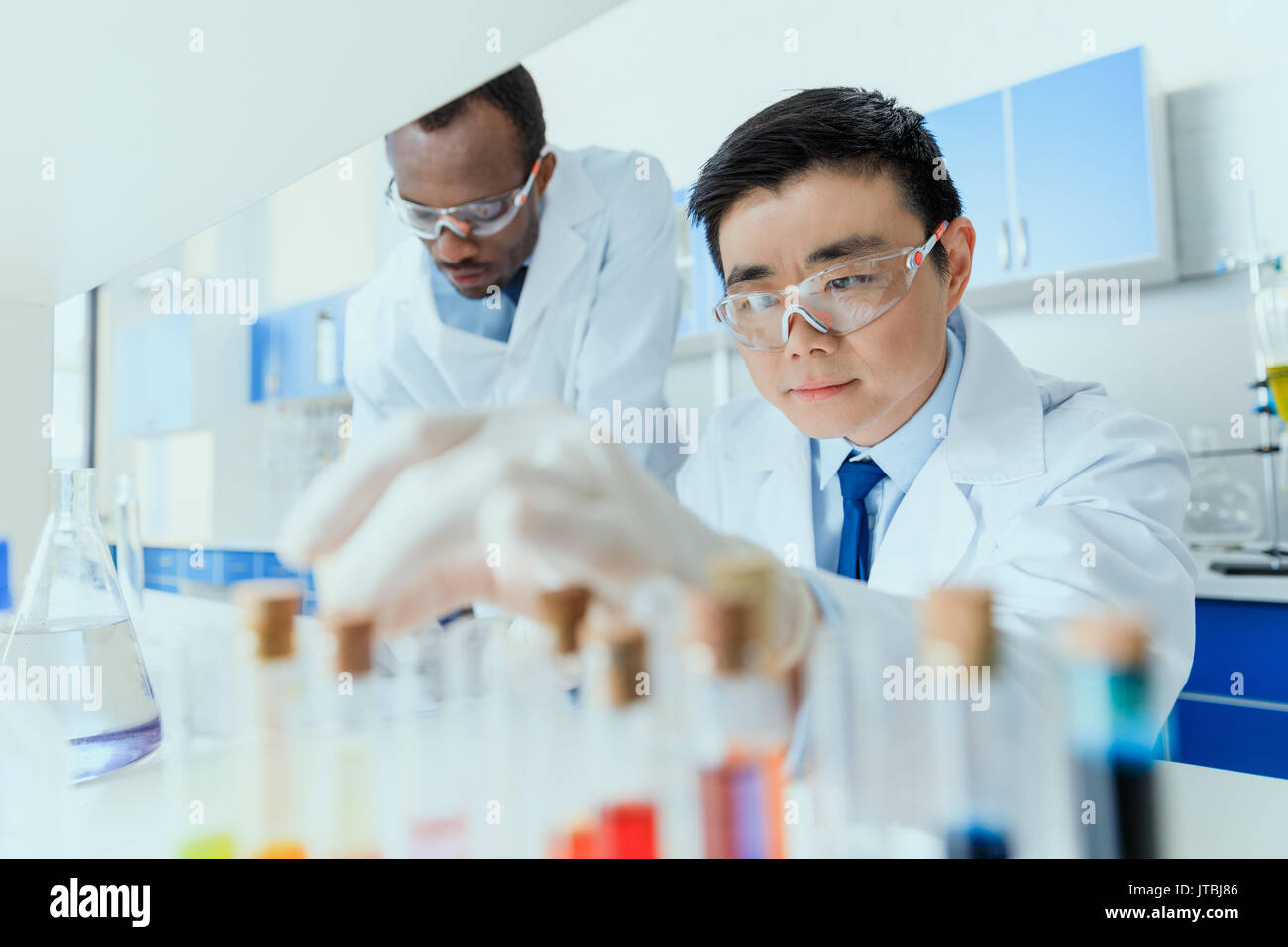 Professional scientists in white coats working together in chemical ...