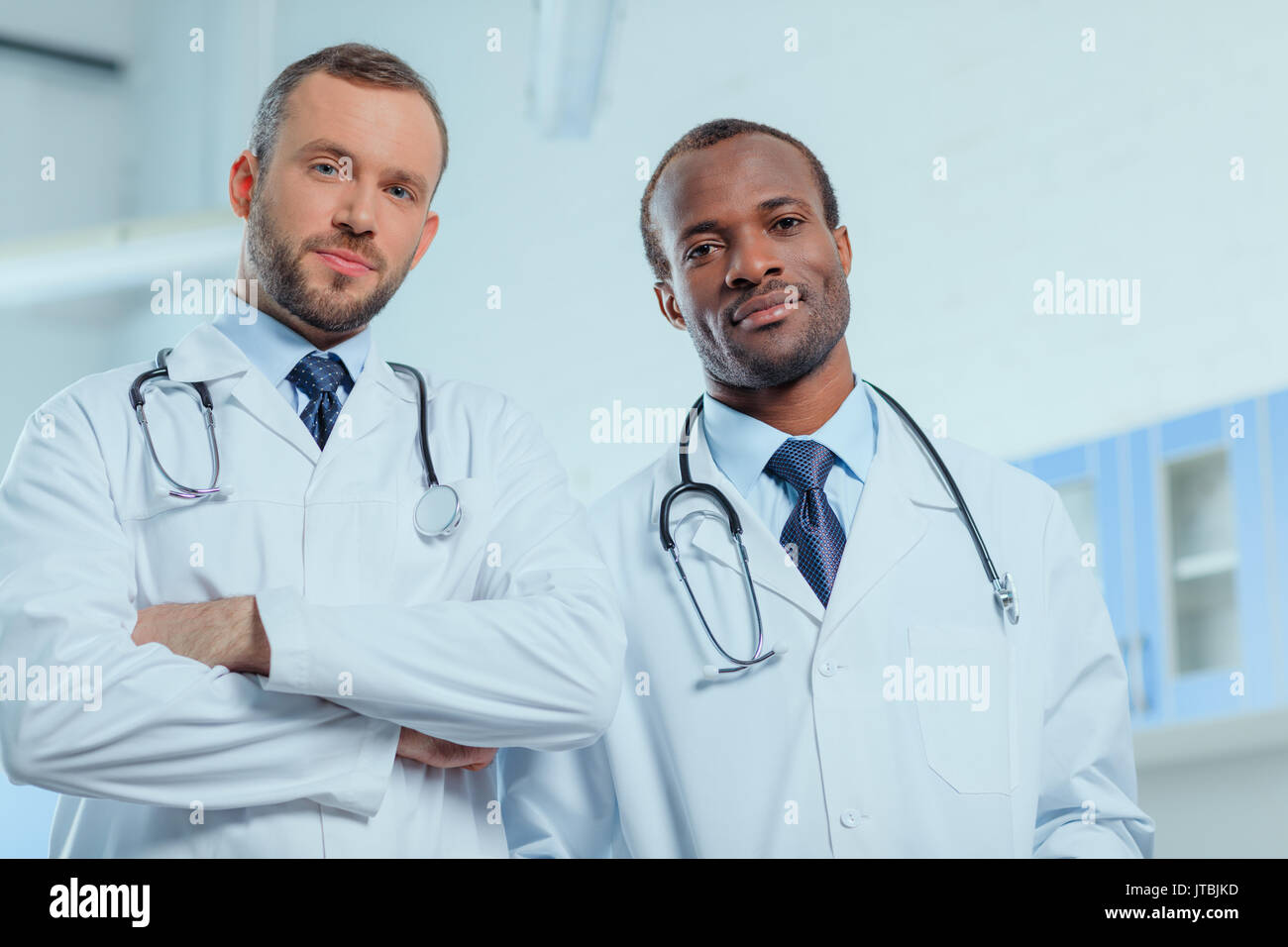 portrait of multiracial group of doctors in medical uniforms in clinic ...