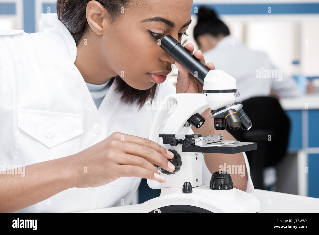 concentrated african american scientist in lab coat working with ...