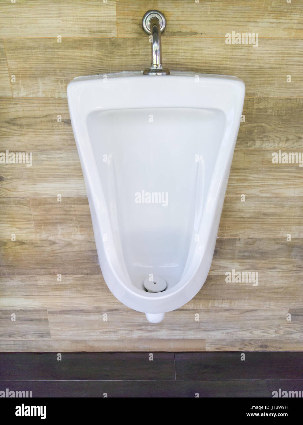 Clean ceramic urinal on the wooden texture tile of the public restroom ...