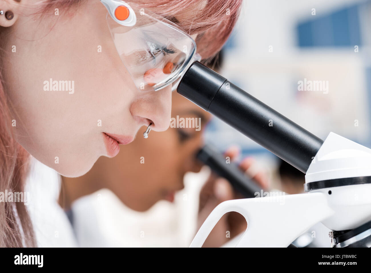 Side view of professional young scientists working with microscopes in chemical laboratory Stock ...