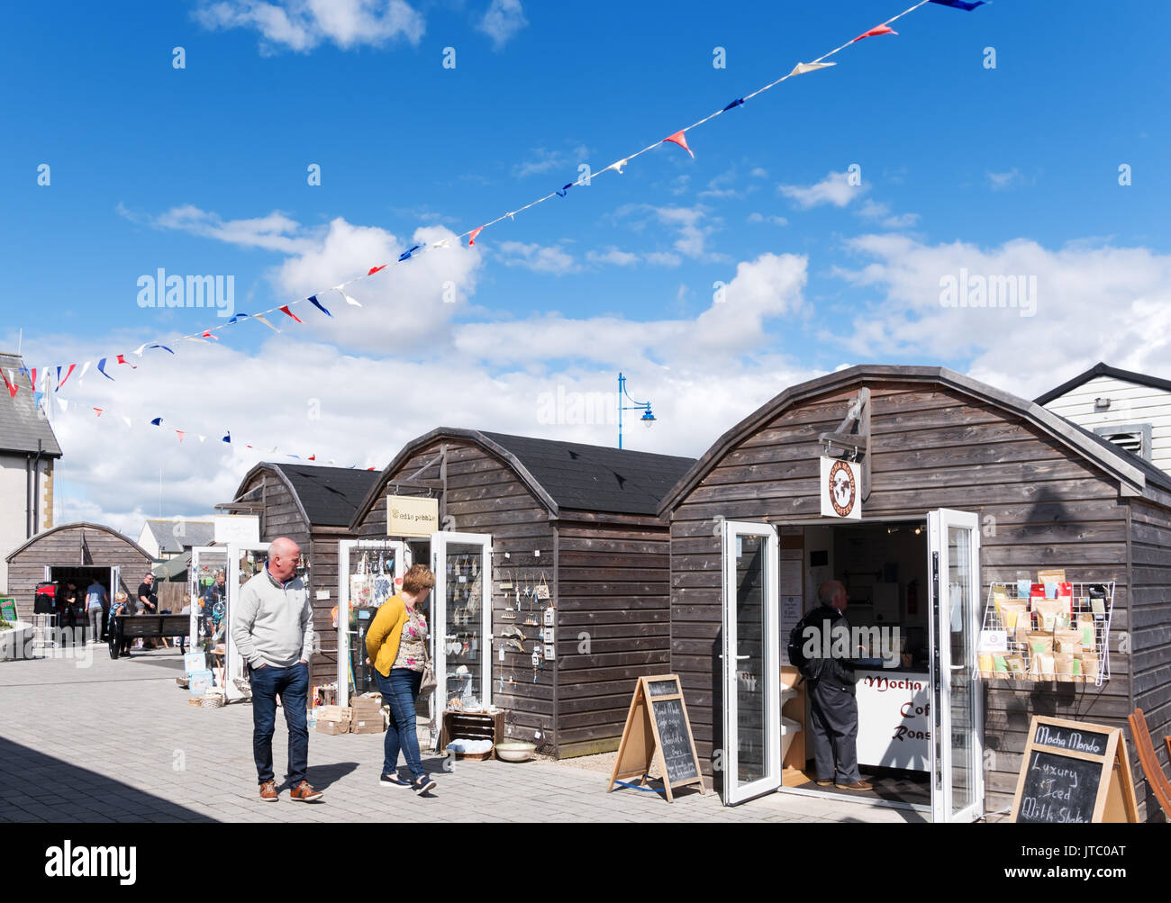 Couple walking through Amble harbour Village, Northumberland, England ...