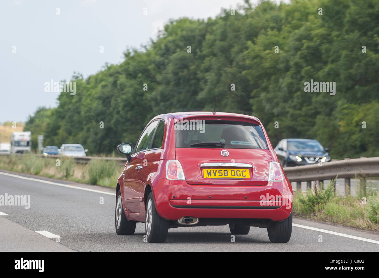 A Red Fiat 500 driving on a main road in the Uk Stock Photo - Alamy