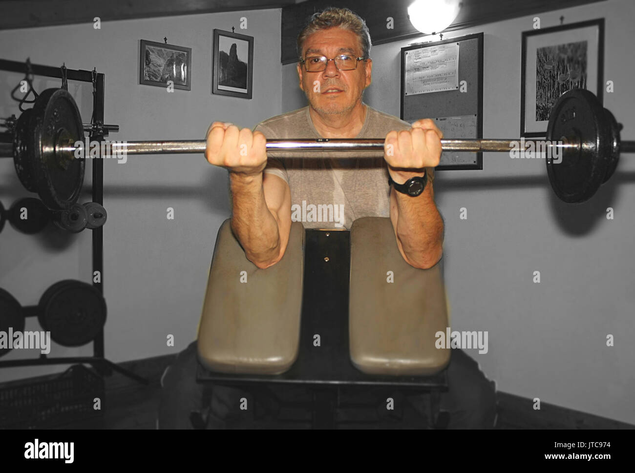 Home gym in the attic, biceps with Scott bench Stock Photo - Alamy