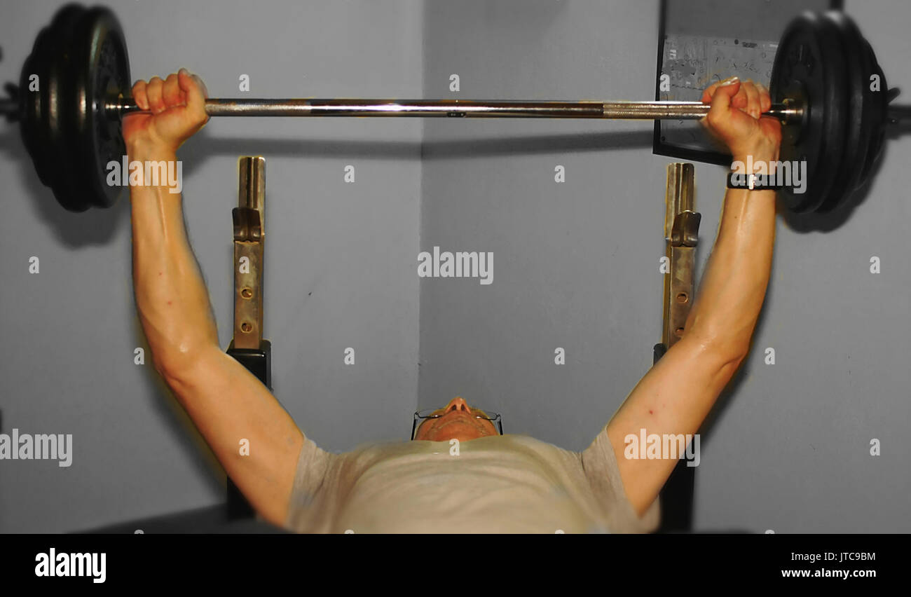 Home gym in the attic, lift on flat bench Stock Photo - Alamy