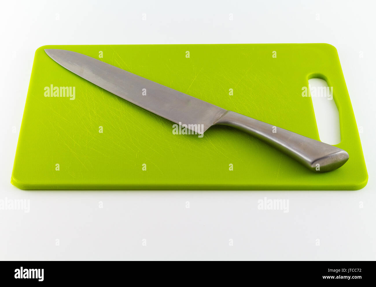 Kitchen knife on green cutting board Stock Photo - Alamy