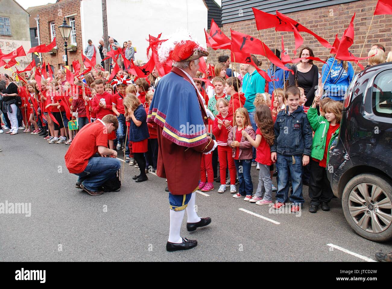 Rex Swain, Town Crier, walks past people lining the street at an ...