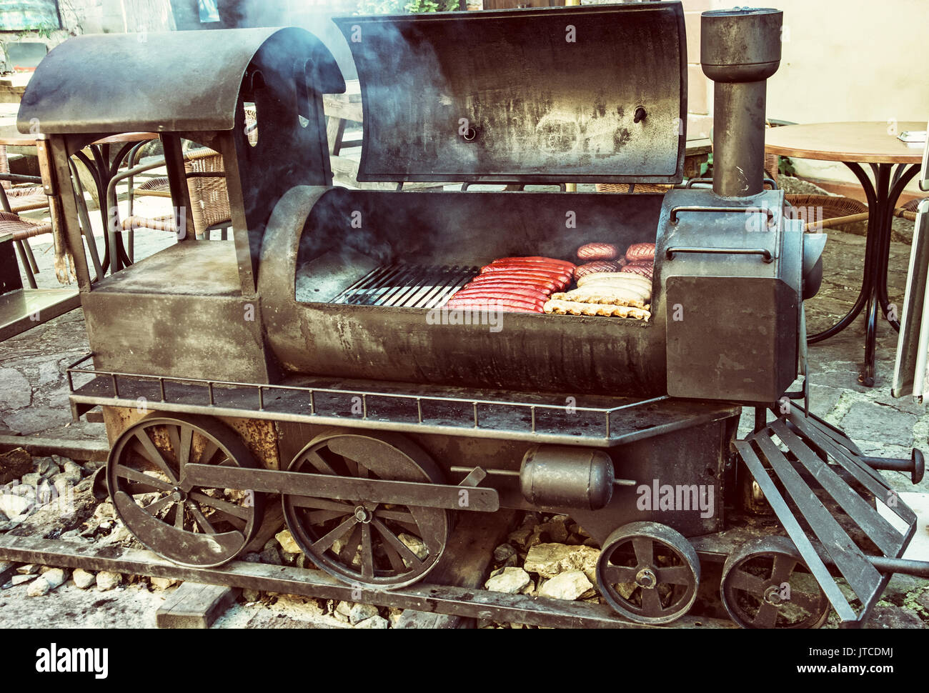 Barbecue grill with meat in shape of old steam locomotive. Bbq scene ...