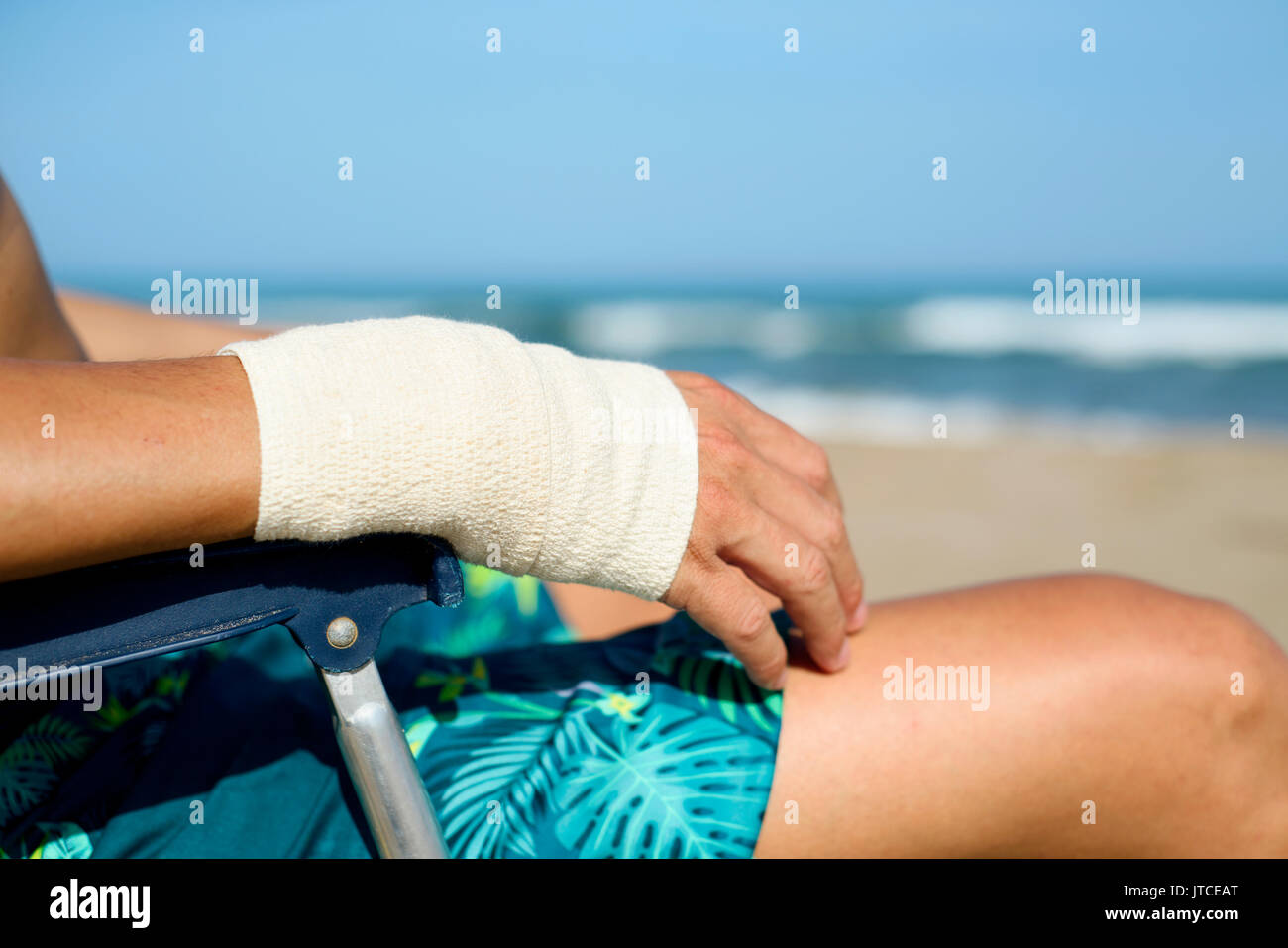 closeup of a young caucasian man in swimsuit sitting in a deck chair on ...