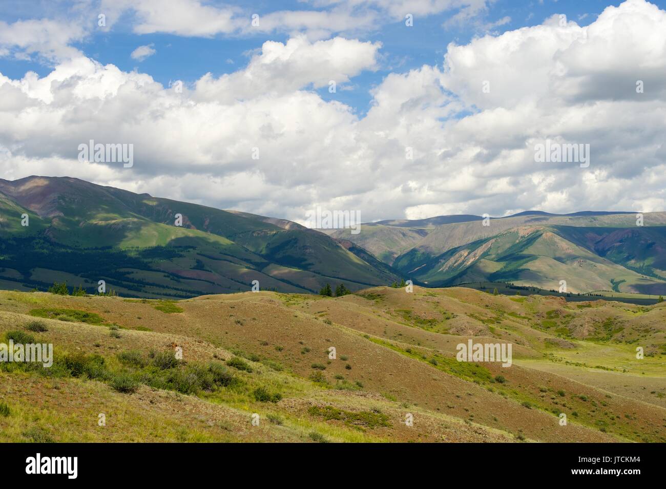 Beautiful sunny valley between mountains with lush clouds Stock Photo ...