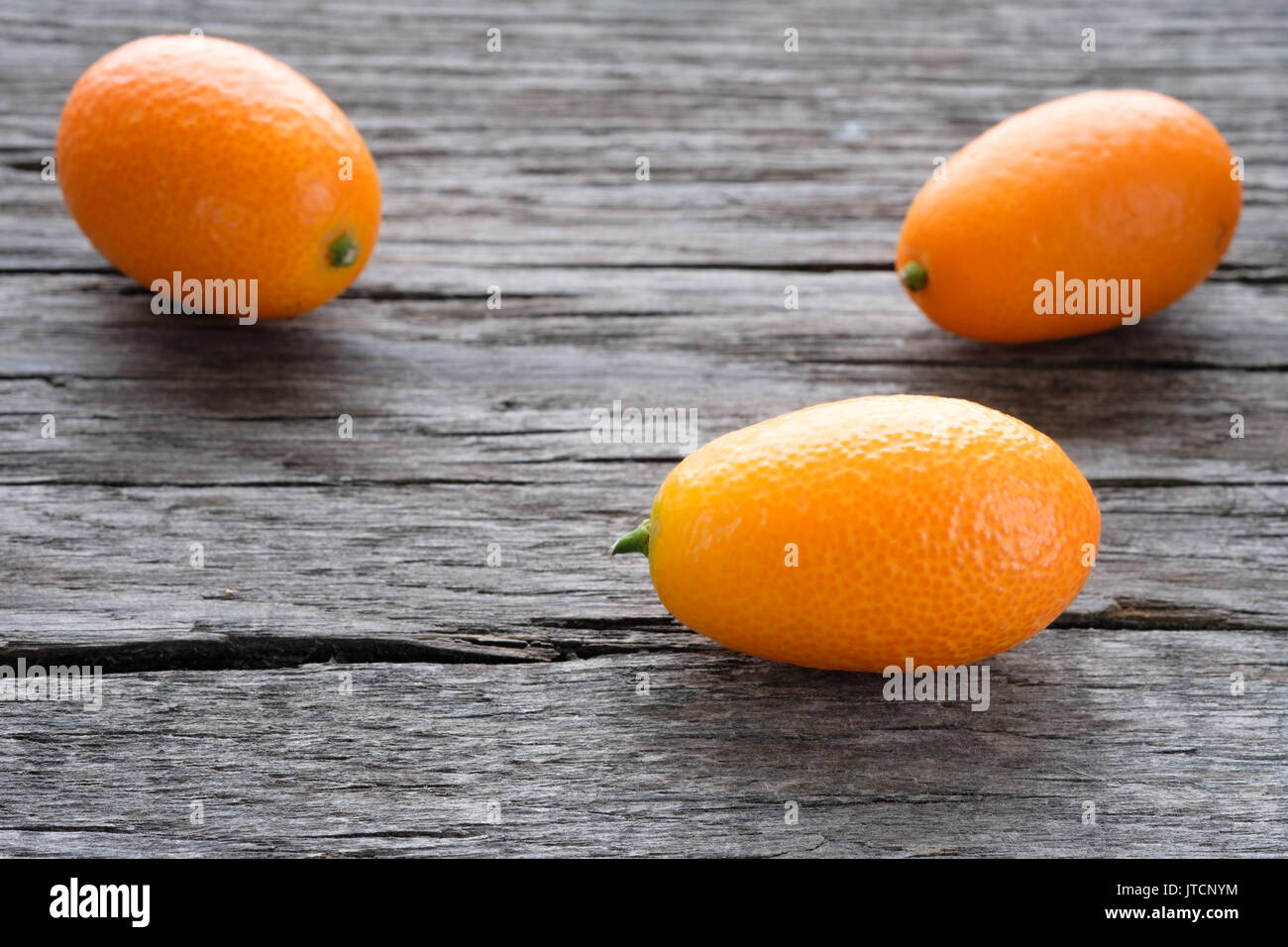 Kumquat fruit on rustic wood in backlight Stock Photo - Alamy