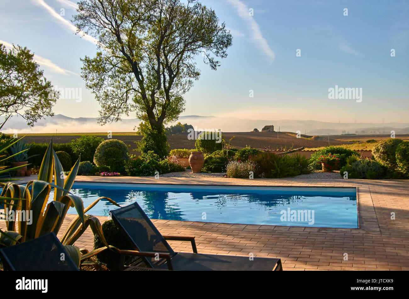 Swimming pool in early morning sun and mist Stock Photo - Alamy