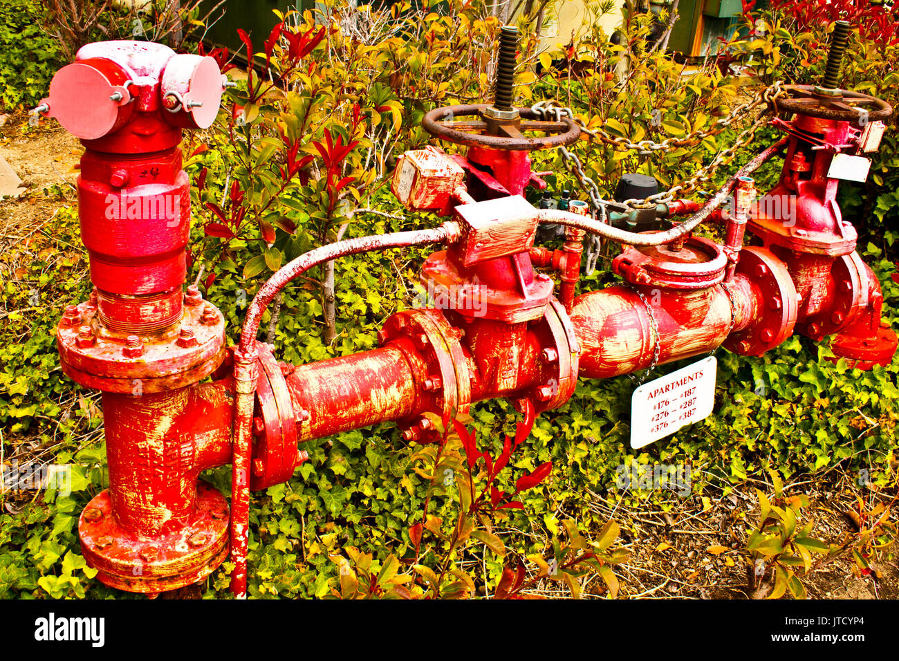 Big pipes wiith red paint flaking off Stock Photo - Alamy