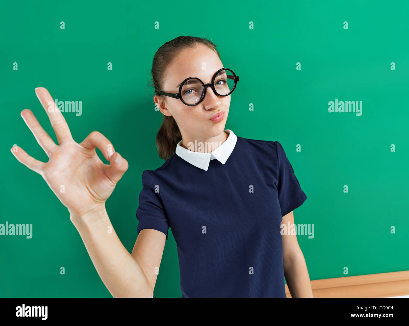 Cool student showing okay gesture. Photo of teen near blackboard ...