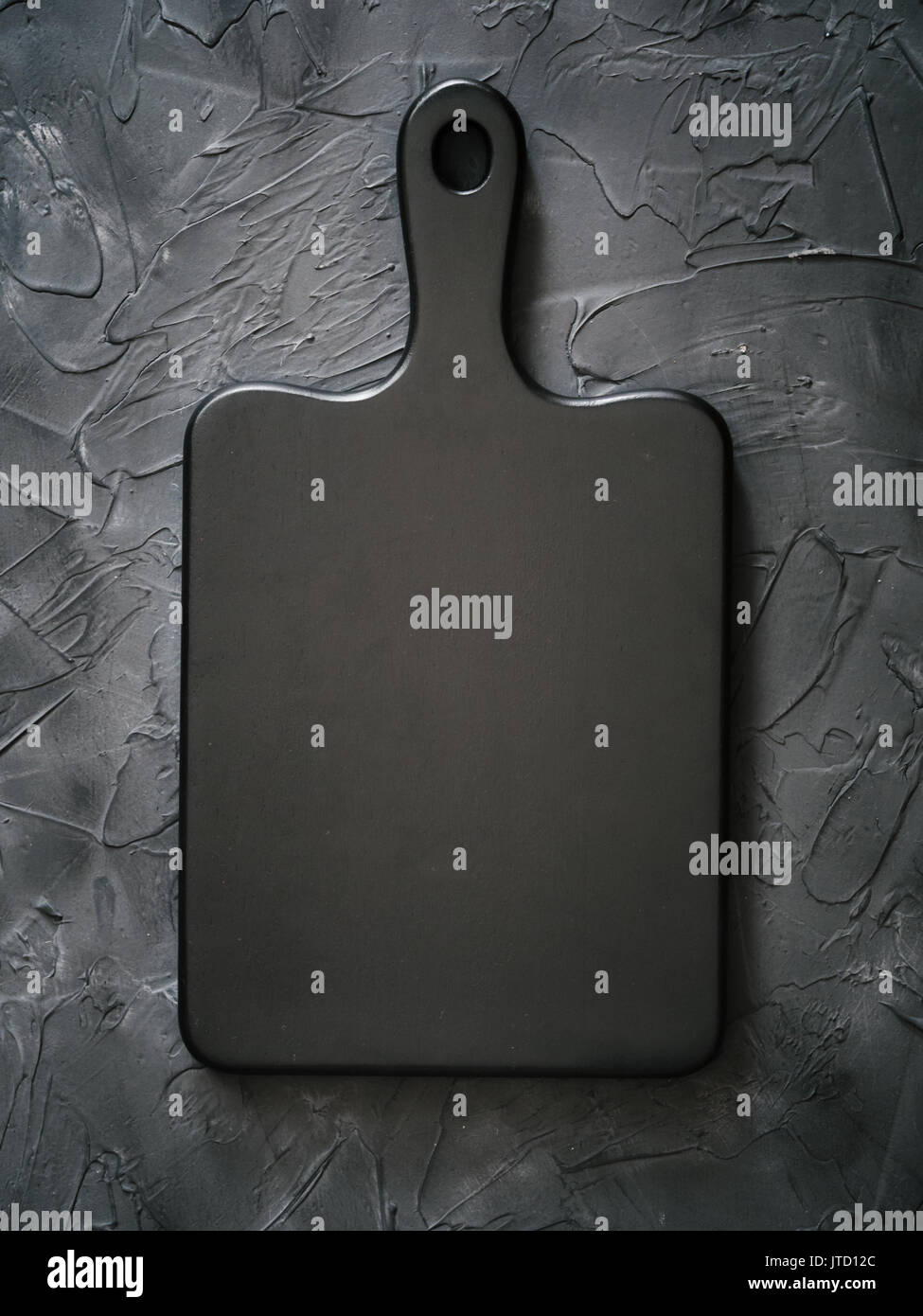 black wooden cutting board on black background Stock Photo - Alamy