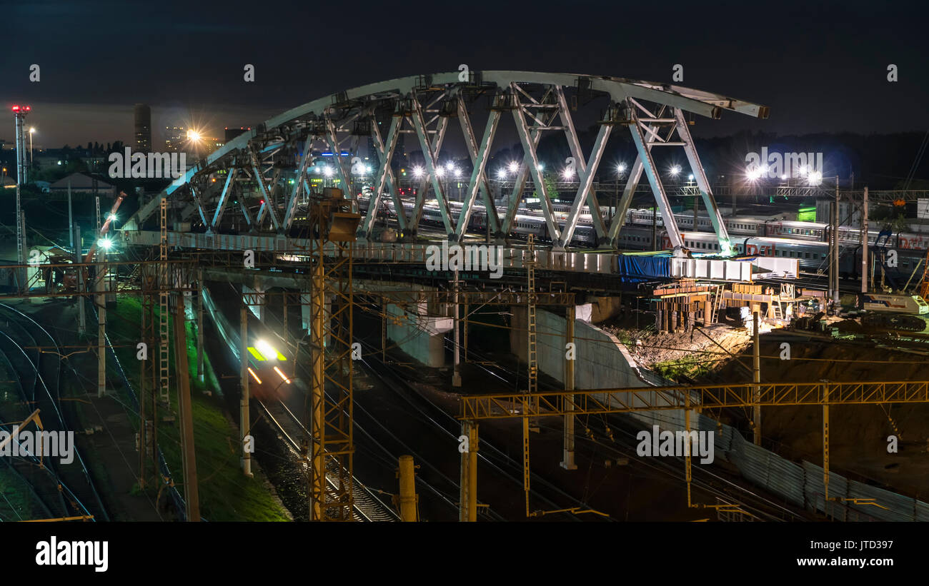 The construction of a steel bridge and night movement of trains on a ...