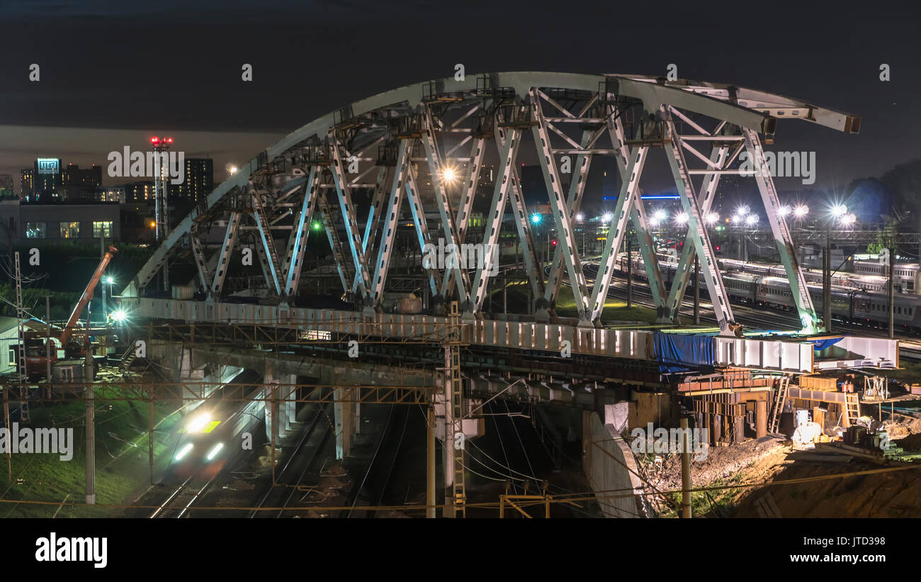 The construction of a steel bridge and night movement of trains on a ...