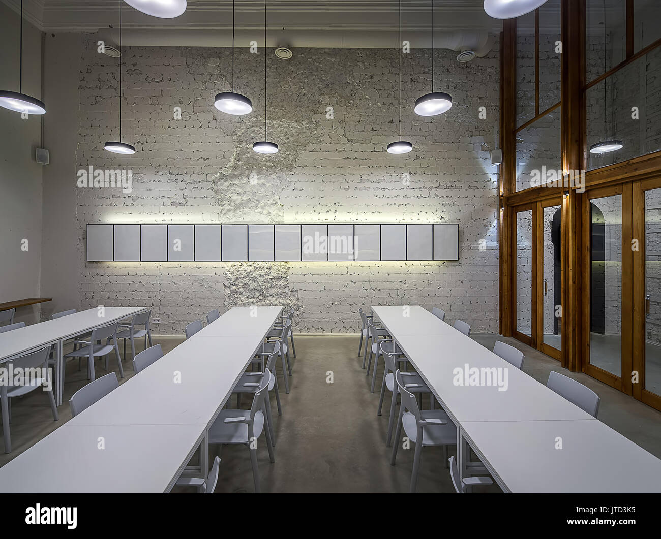 Luminous hall in the cafe with shabby light walls and gray floor. There ...