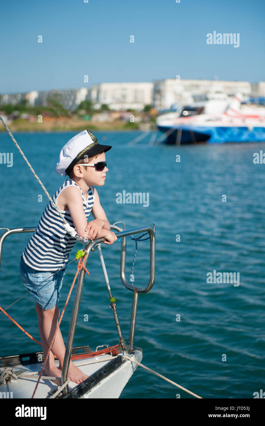 cool cute little boy captain wearing sunglasses aboard luxury boat ...