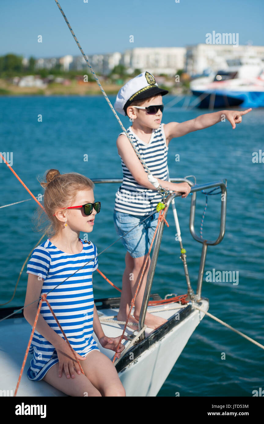 happy cute kids aboard luxury yacht in summer sunny day in port Stock ...