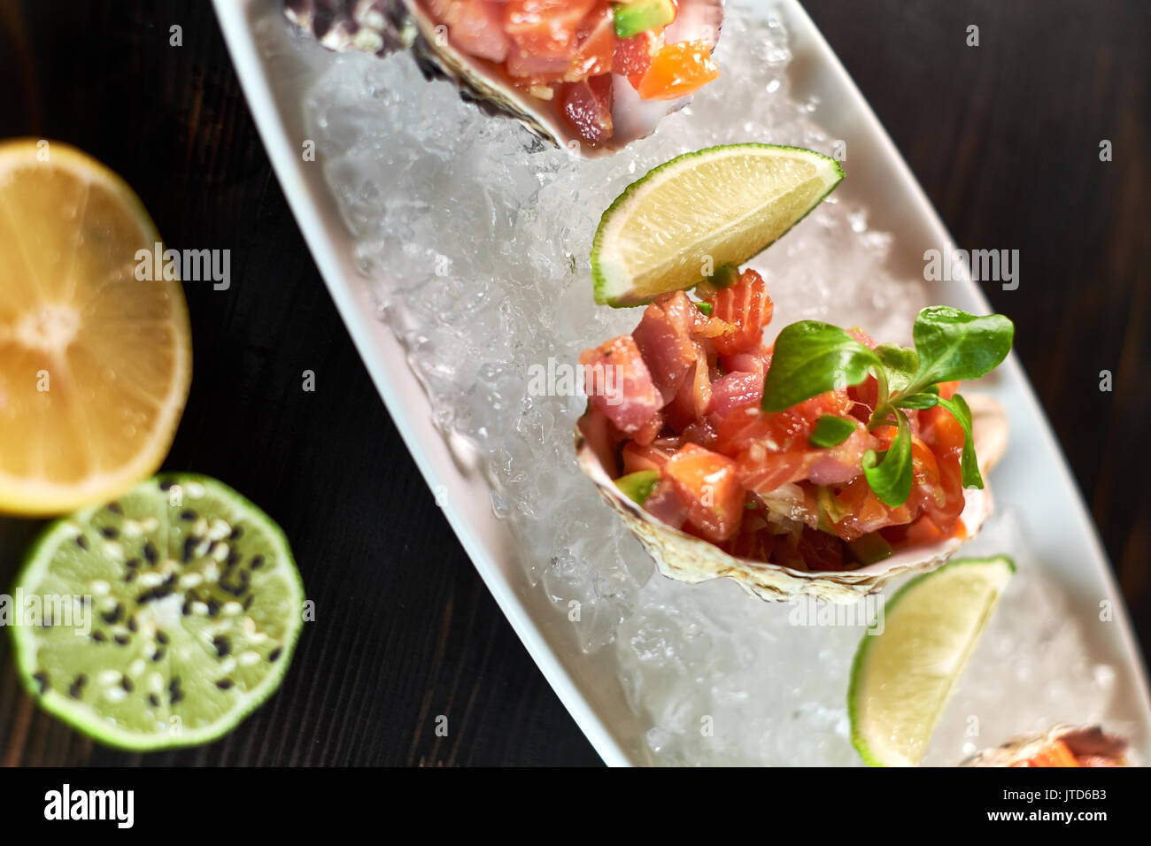 Delicious red fish in the shells of shellfish. With lemon and lime jpg ...