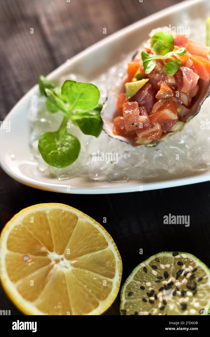 Delicious red fish in the shells of shellfish. With lemon and lime jpg ...