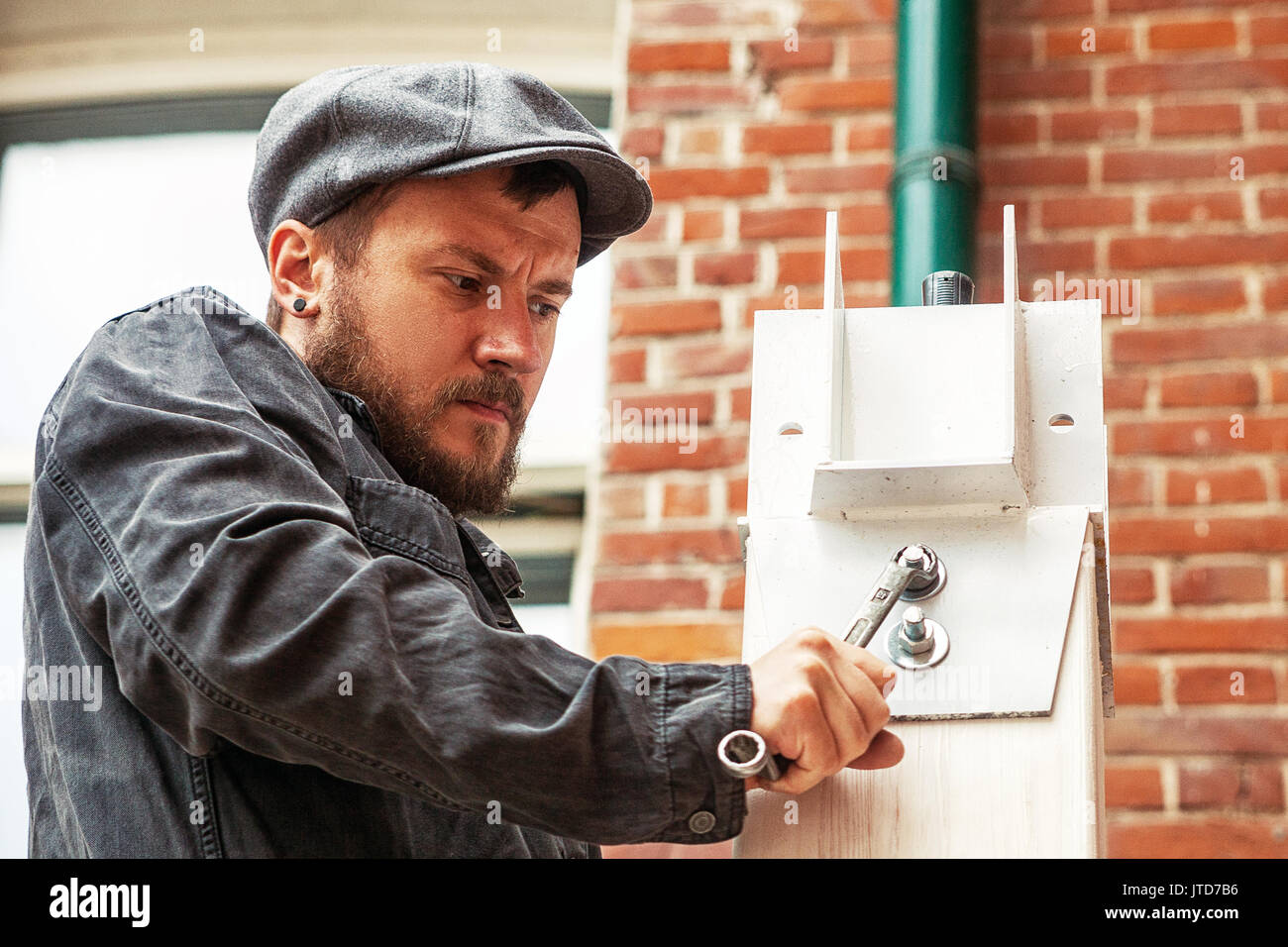 A young man with a beard builder in a construction black uniform, a ...