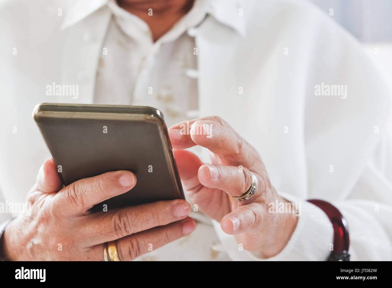 close up image of Senior woman using her mobile phone background. An ...