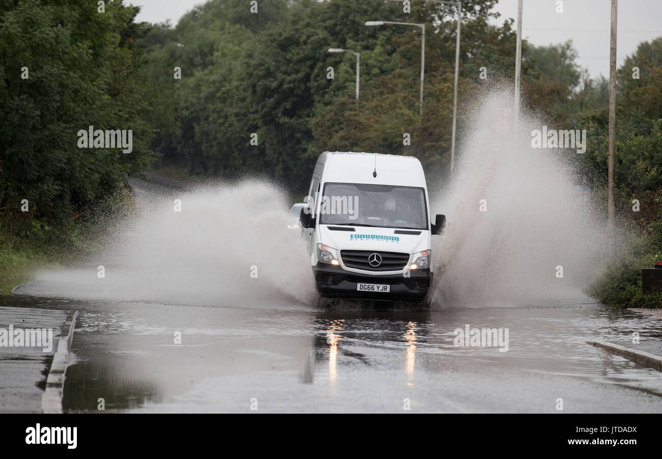 A van goes through a large puddle near Colnbrook, Berkshire as a yellow ...